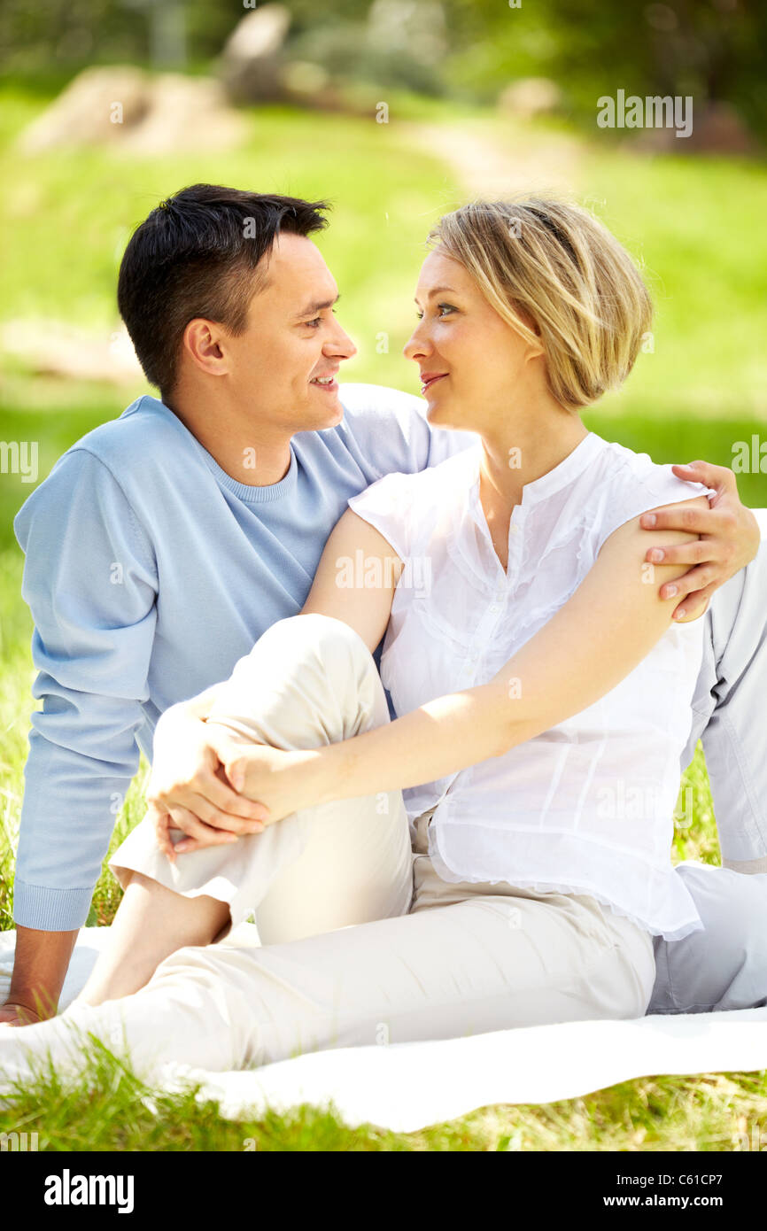Portrait of young amorous couple having rest in park Stock Photo - Alamy
