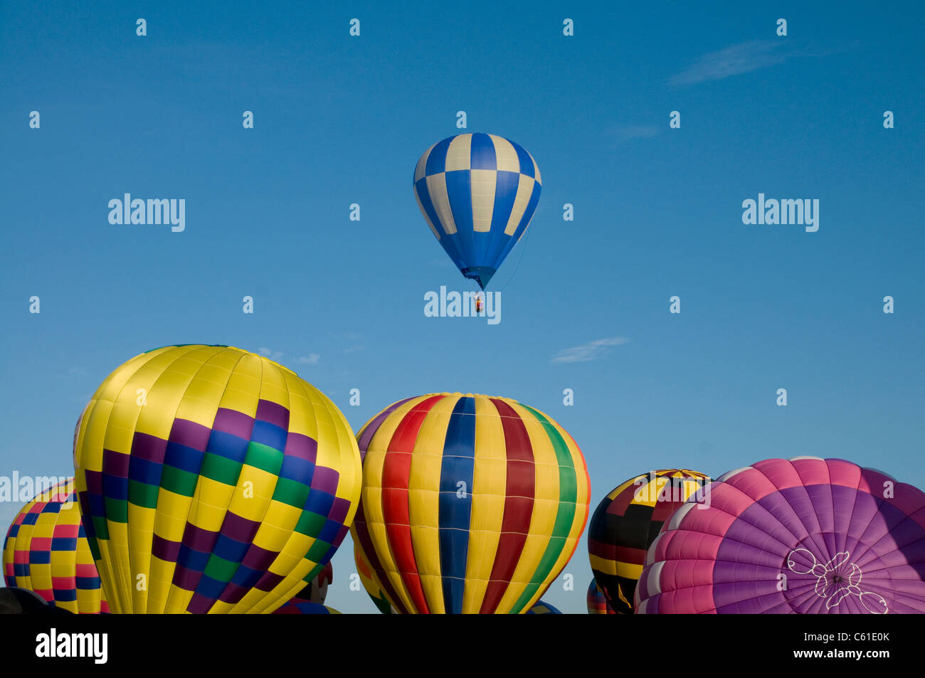 Hot-air balloon ascending over other inflating ones on the ground Stock ...