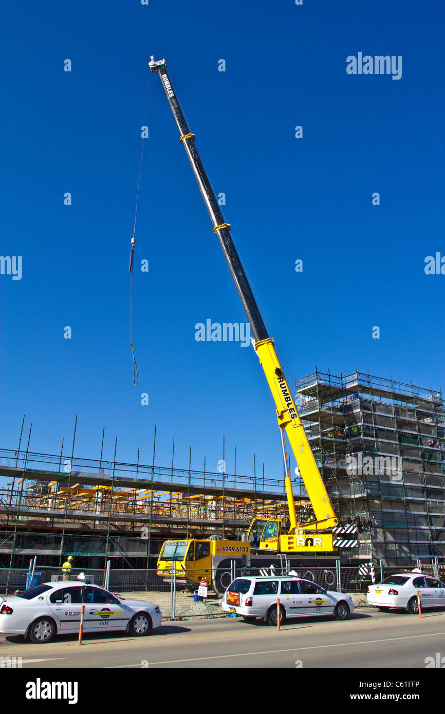 Construction crane lifting loads for building under construction Stock ...