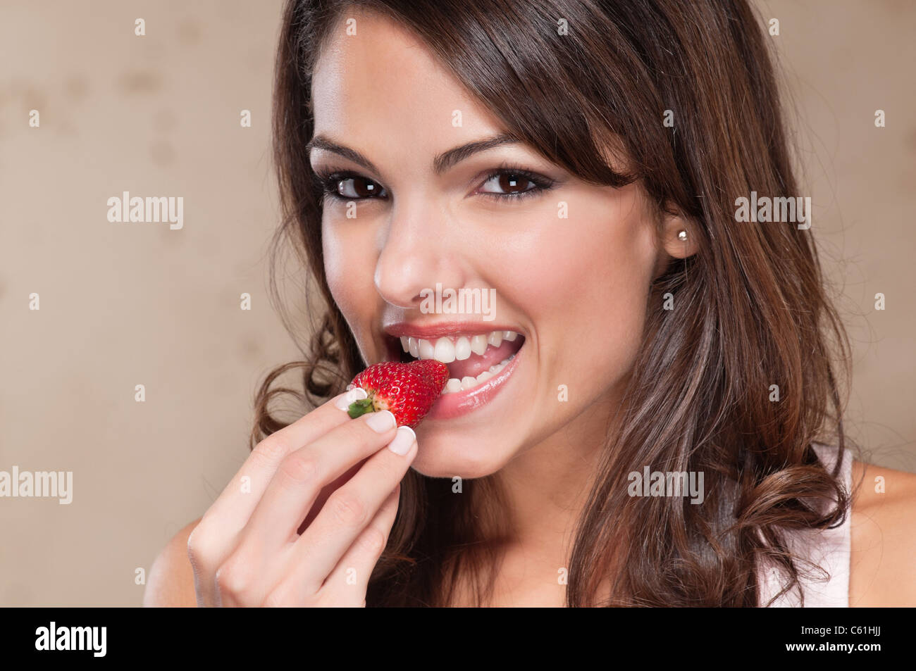 Portrait of pretty young woman eating a strawberry Stock Photo - Alamy