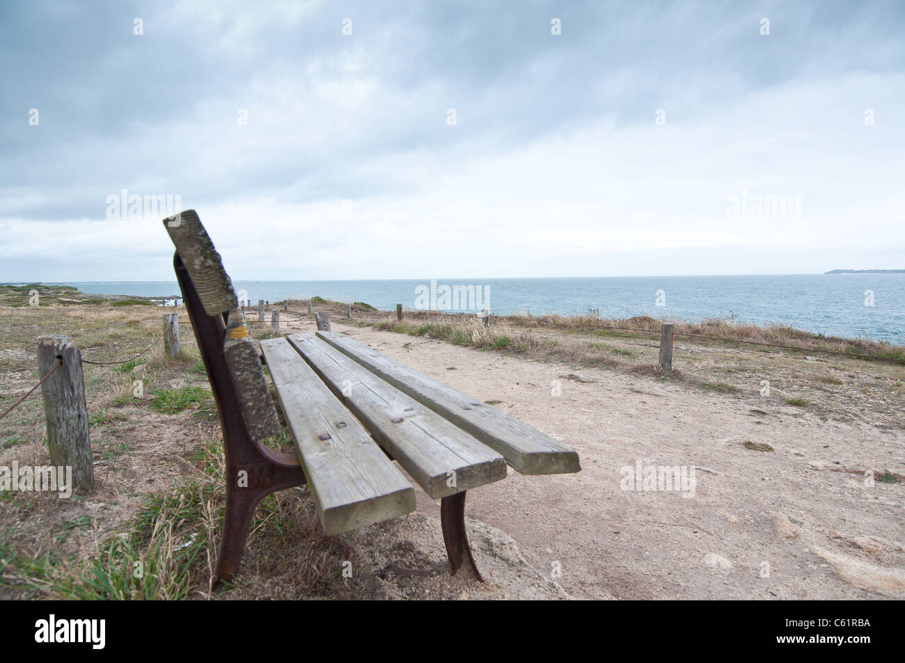Photograph of a wooden bench facing the sea on a walking path in ...