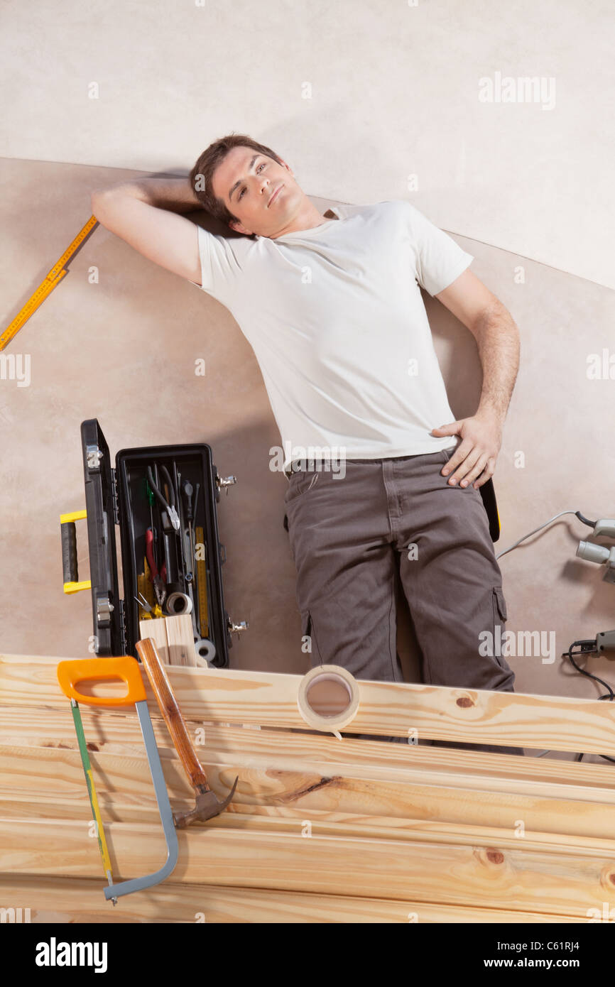 Thoughtful man on the floor with carpentry tools around Stock Photo - Alamy