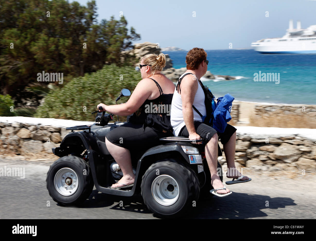 Tourists exploring Mykonos, Greek Island, by quad bike. Mykonos, Greece ...