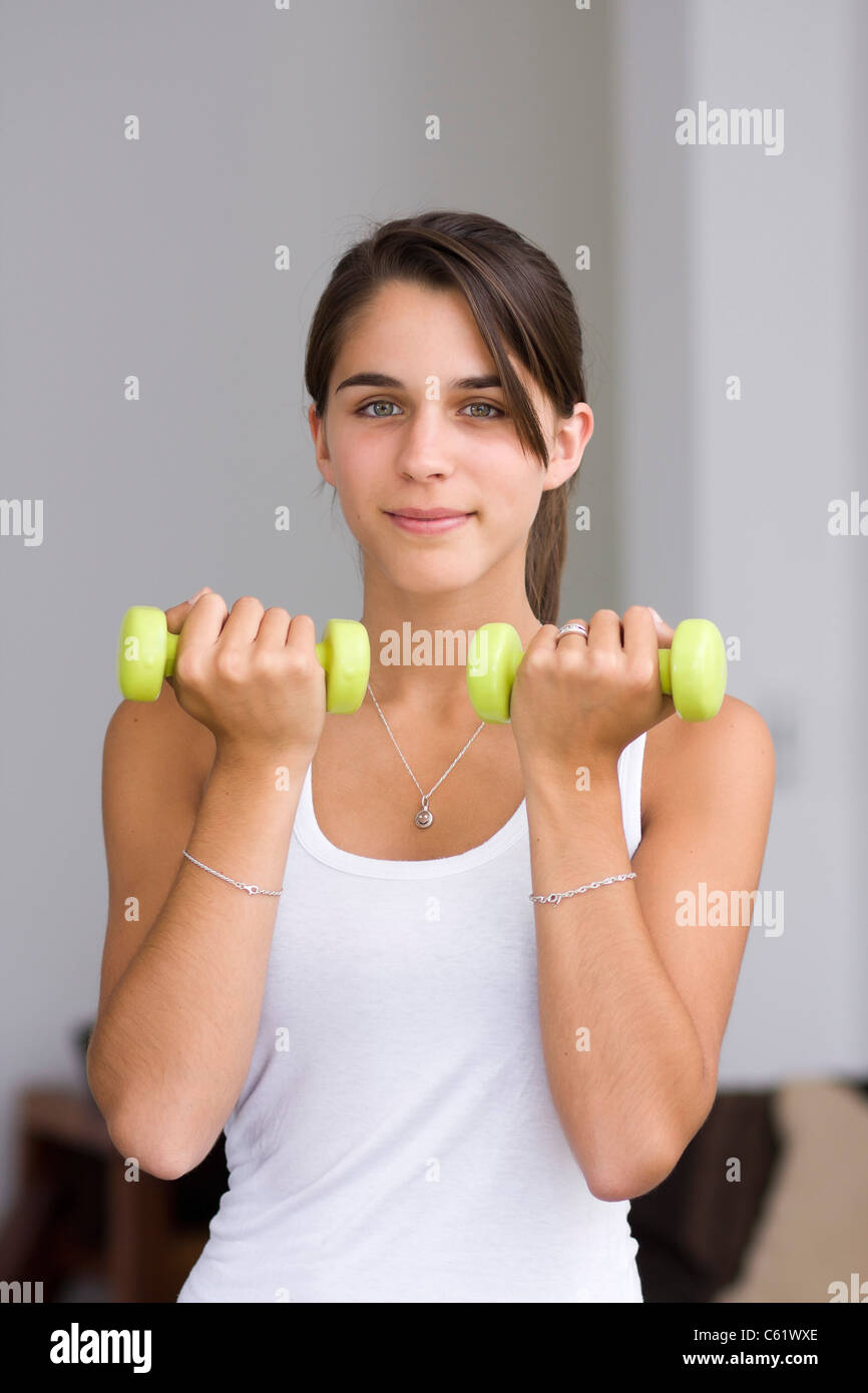 Pretty young woman lifting dumbbells Stock Photo - Alamy