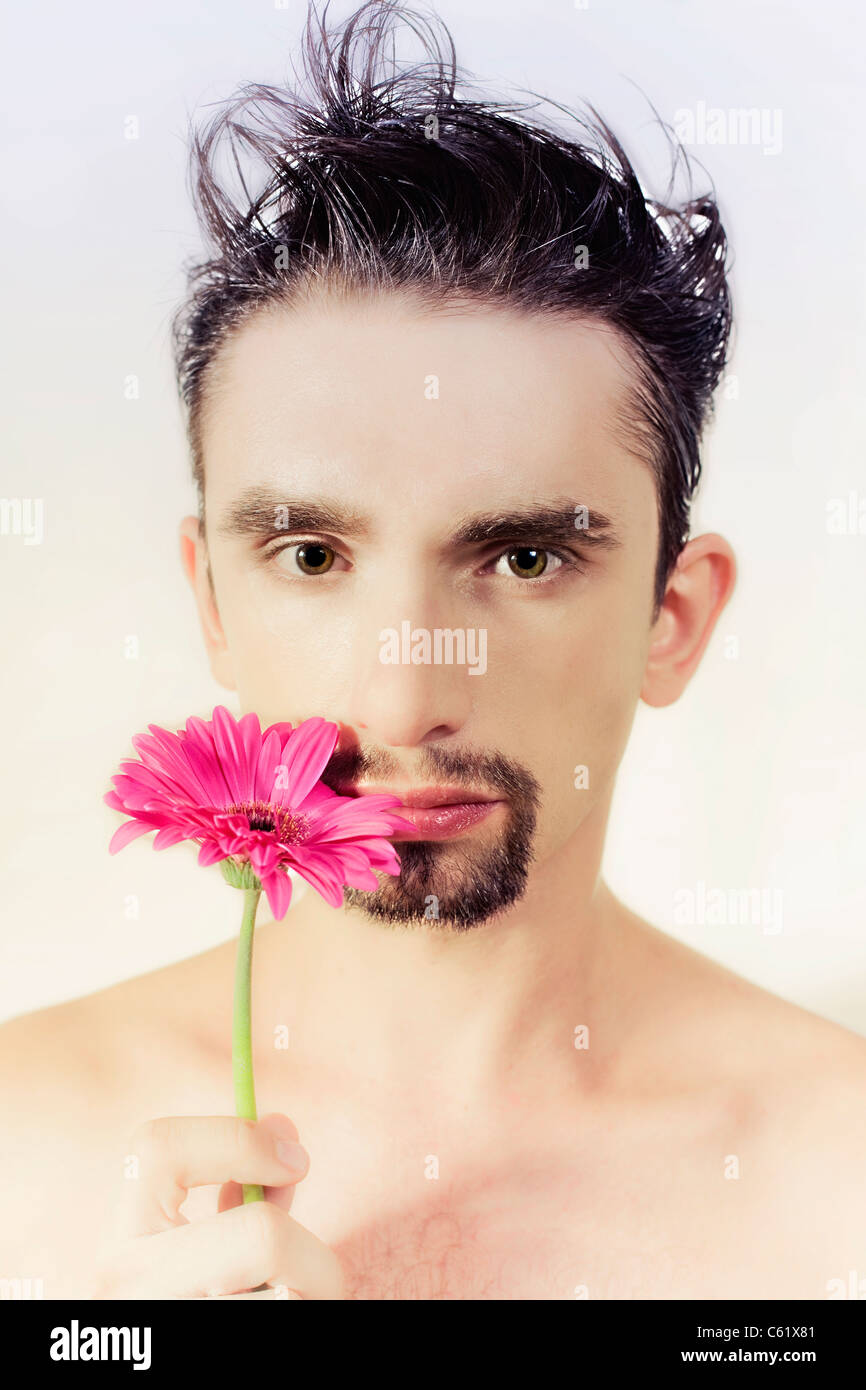 Portrait of a young man with gerberas in a hand close up Stock Photo ...