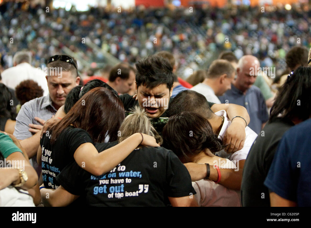 Group engaged in huddle while praying at a Christian faith all-day ...