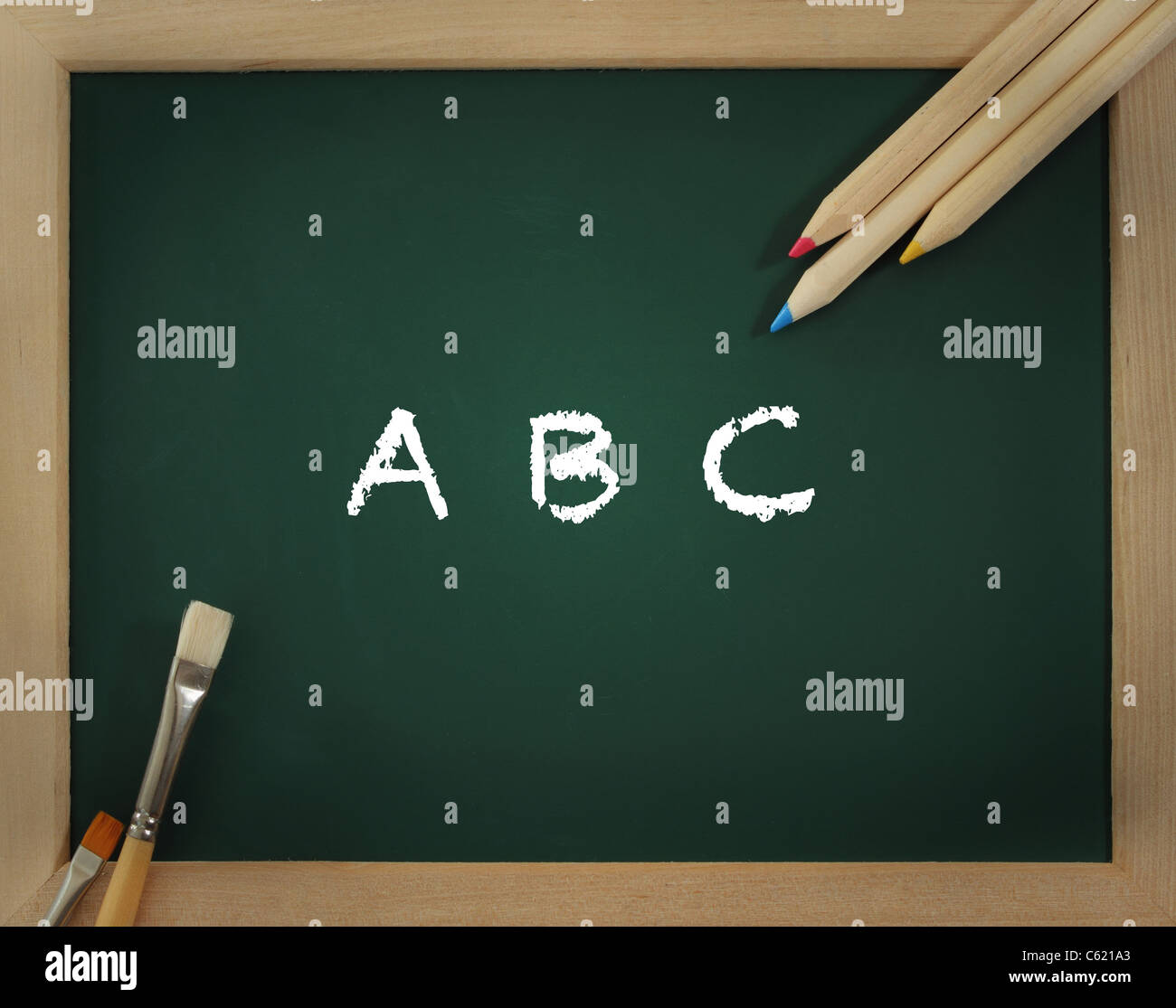 Green clear blackboard with brushes and pencils Stock Photo - Alamy