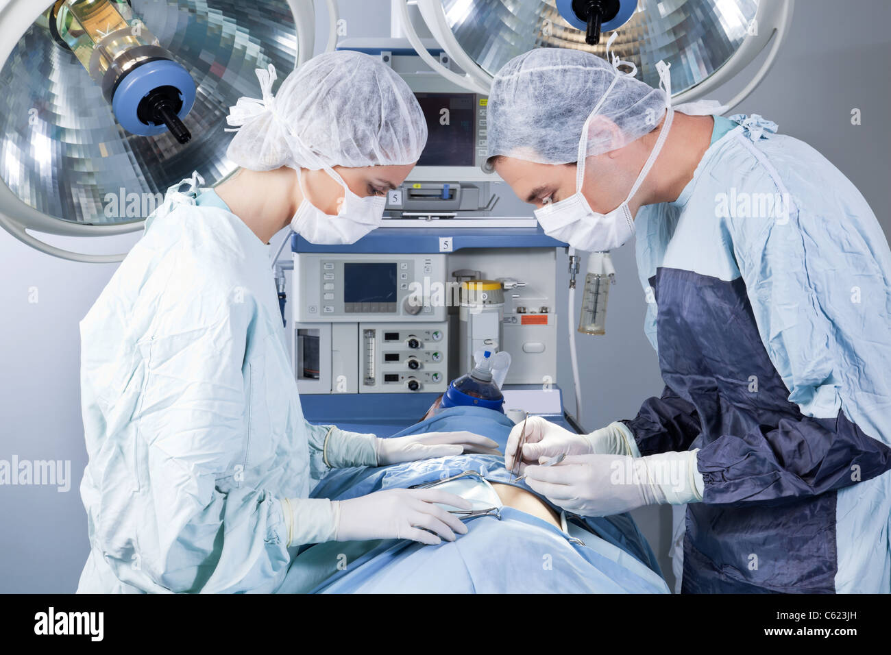 Medical professionals performing an operation on patient in operation ...