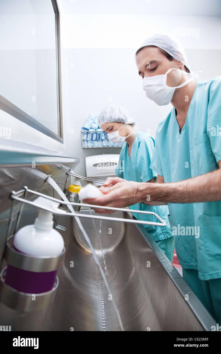 Male and female doctor washing hands with hand sanitizer Stock Photo ...