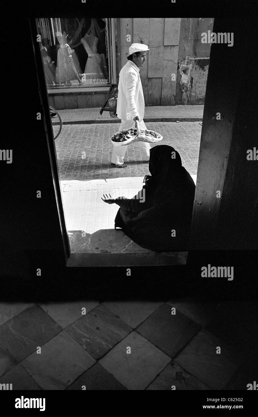 A beggar in church doorway, Cadiz, Spain. Vintage black and white image ...