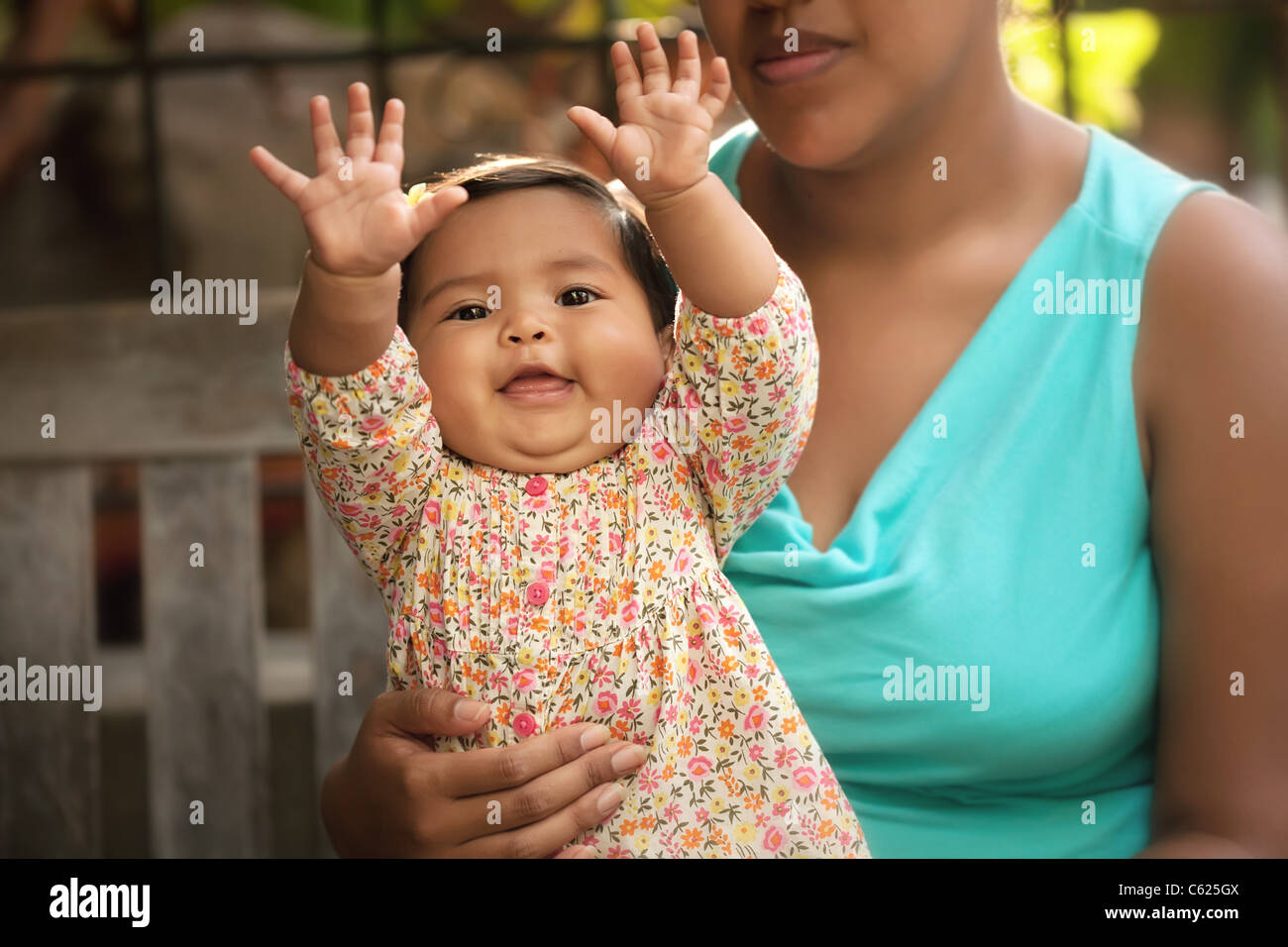baby girl reaching with her arms being supported by her mother Stock ...