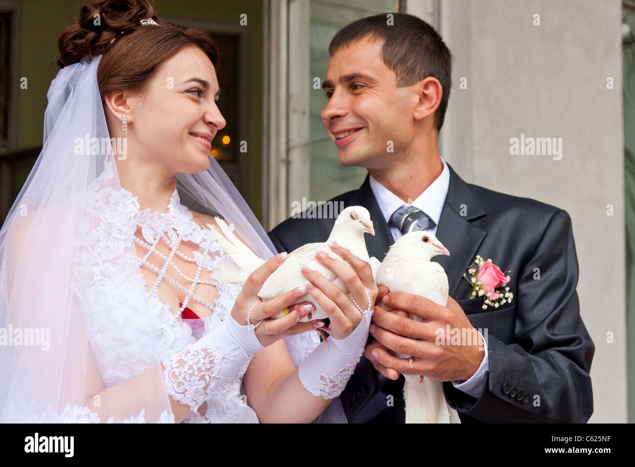 Happy groom and bride holding wedding pigeons in hands Stock Photo - Alamy