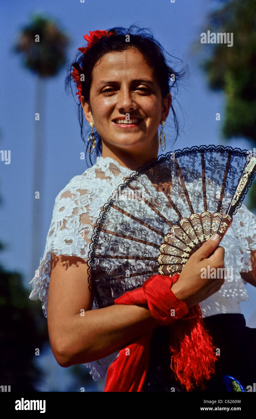 Portrait of smiling mexican woman in traditional costume holding a fan ...