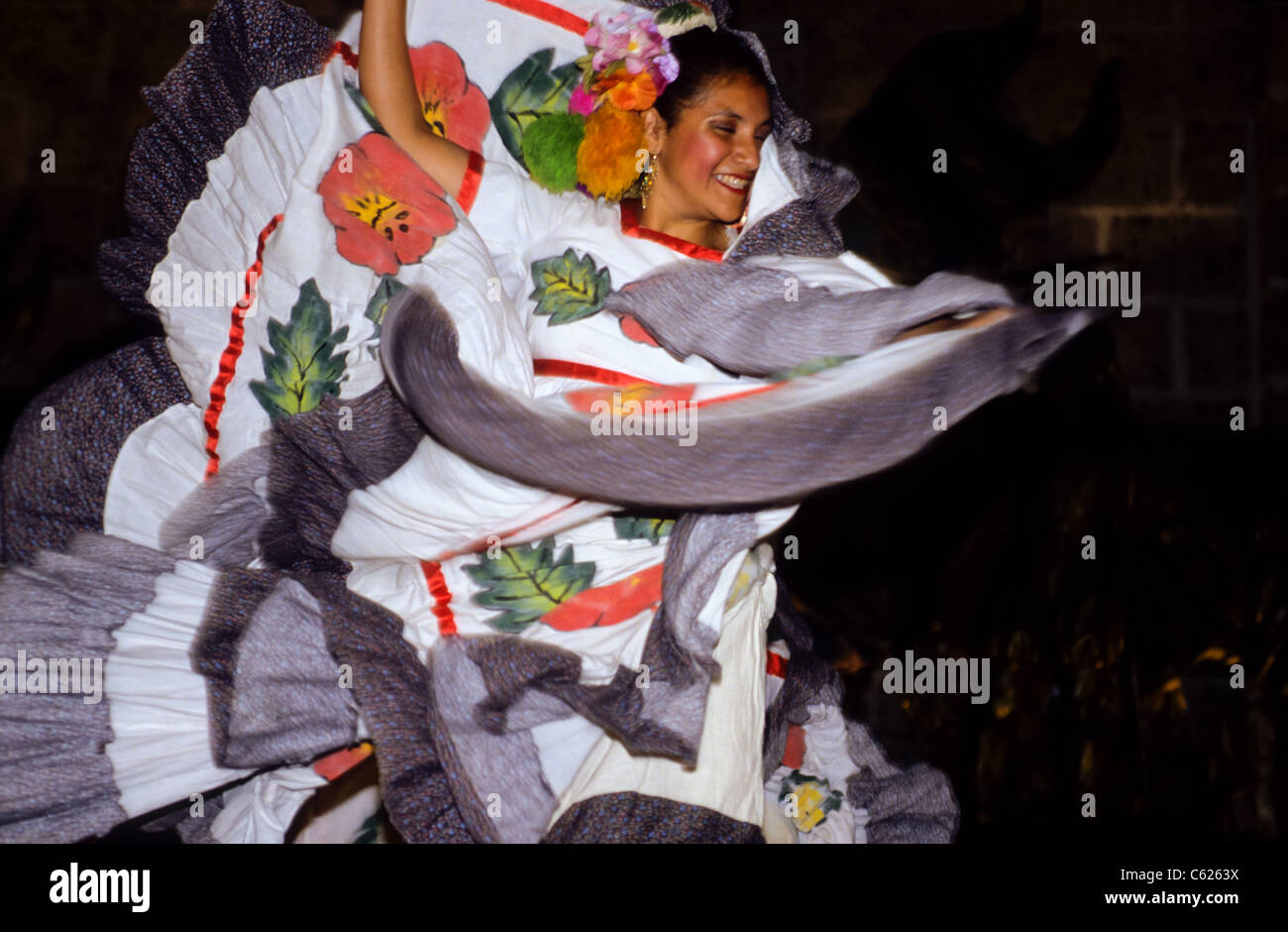 Smiling flamingo danser swinging her gown in a time exposure showing ...