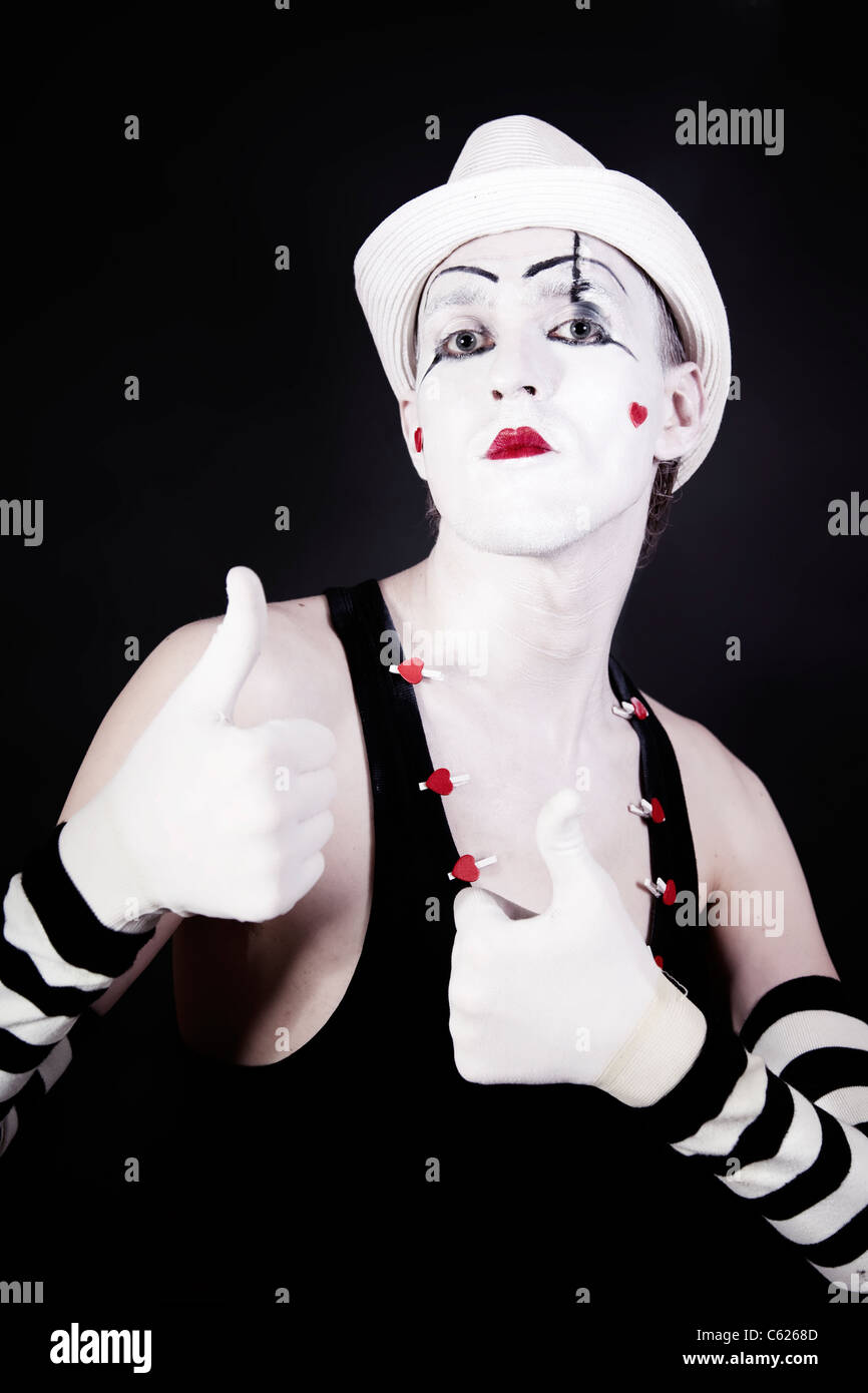 theater actor in makeup and a white hat on a black background Stock ...