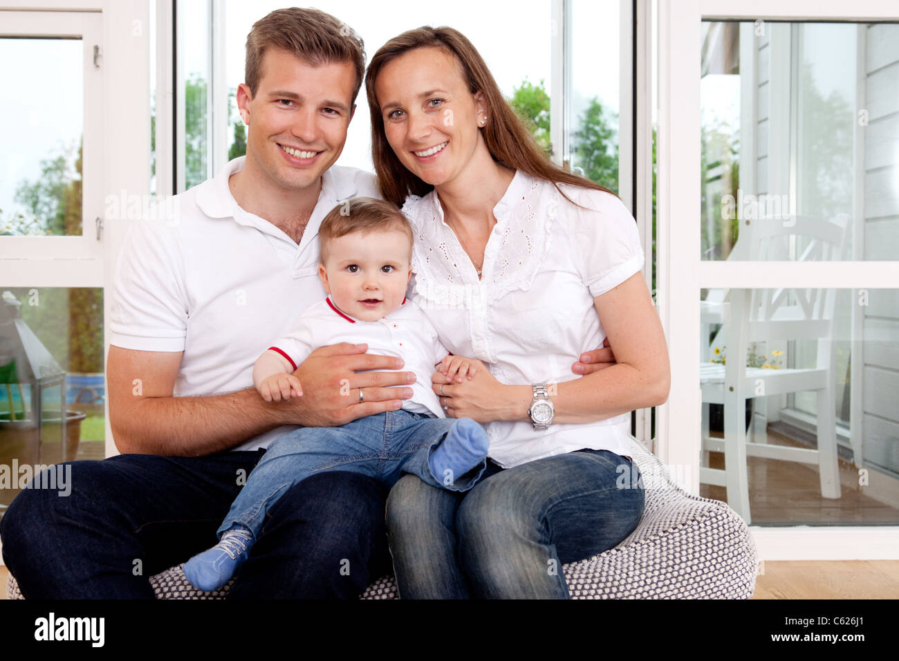 Portrait of a happy family looking at the camera in a home interior ...