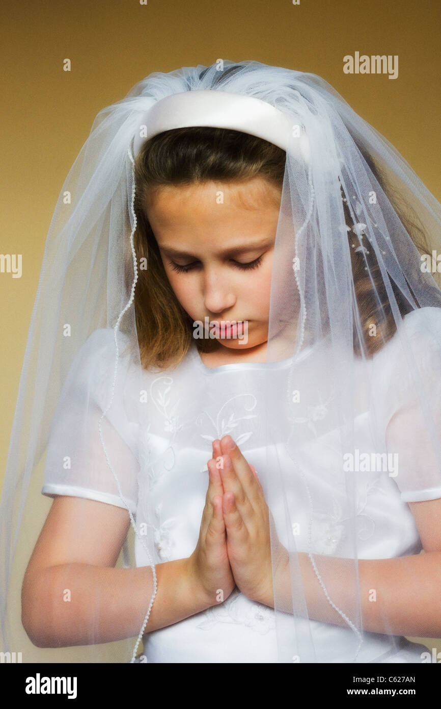 Child praying in first holy communion dress Stock Photo - Alamy