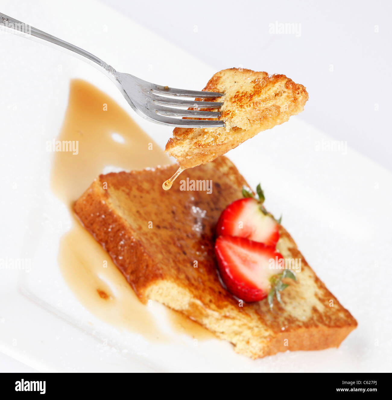 French toast with drip of syrup and strawberries on white background ...