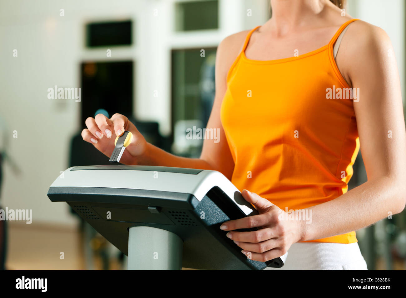 Woman in gym or health club reading her training plan which is stored ...