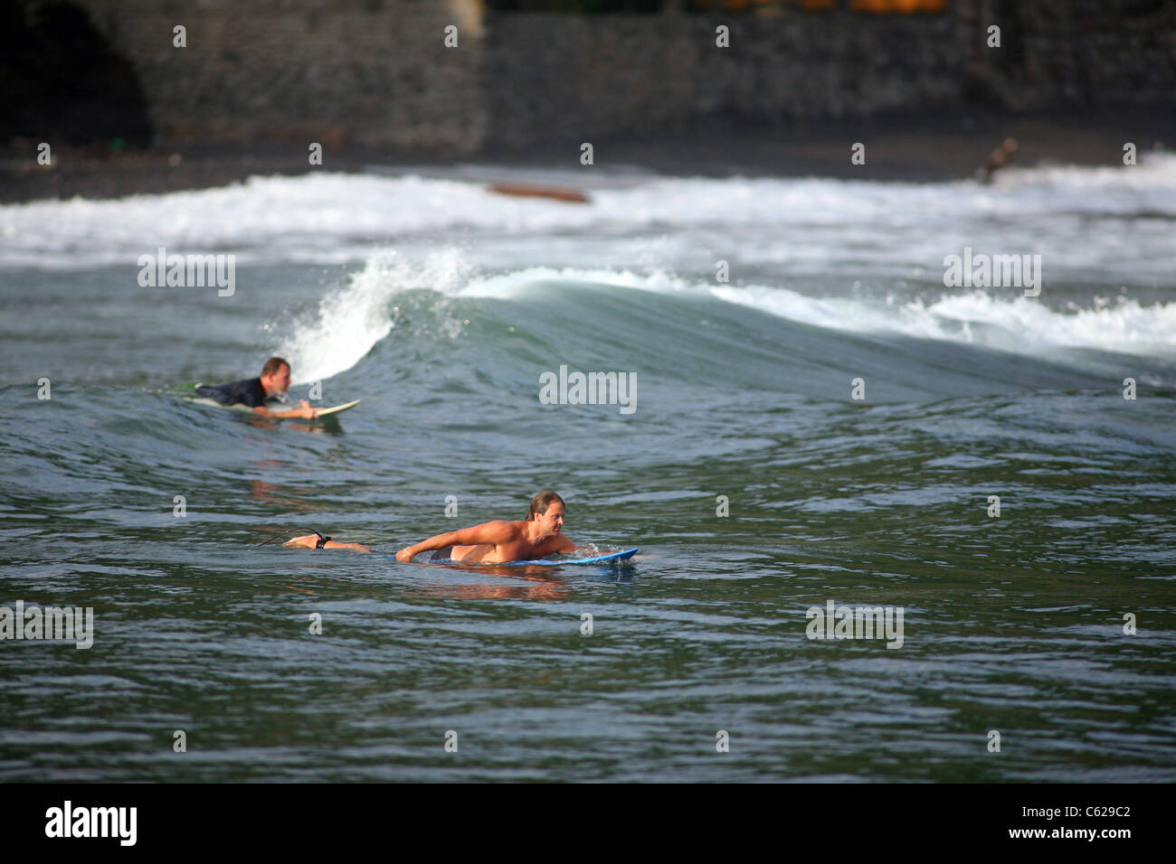 Surfers paddling out at the right point break. El Salvador Stock Photo ...