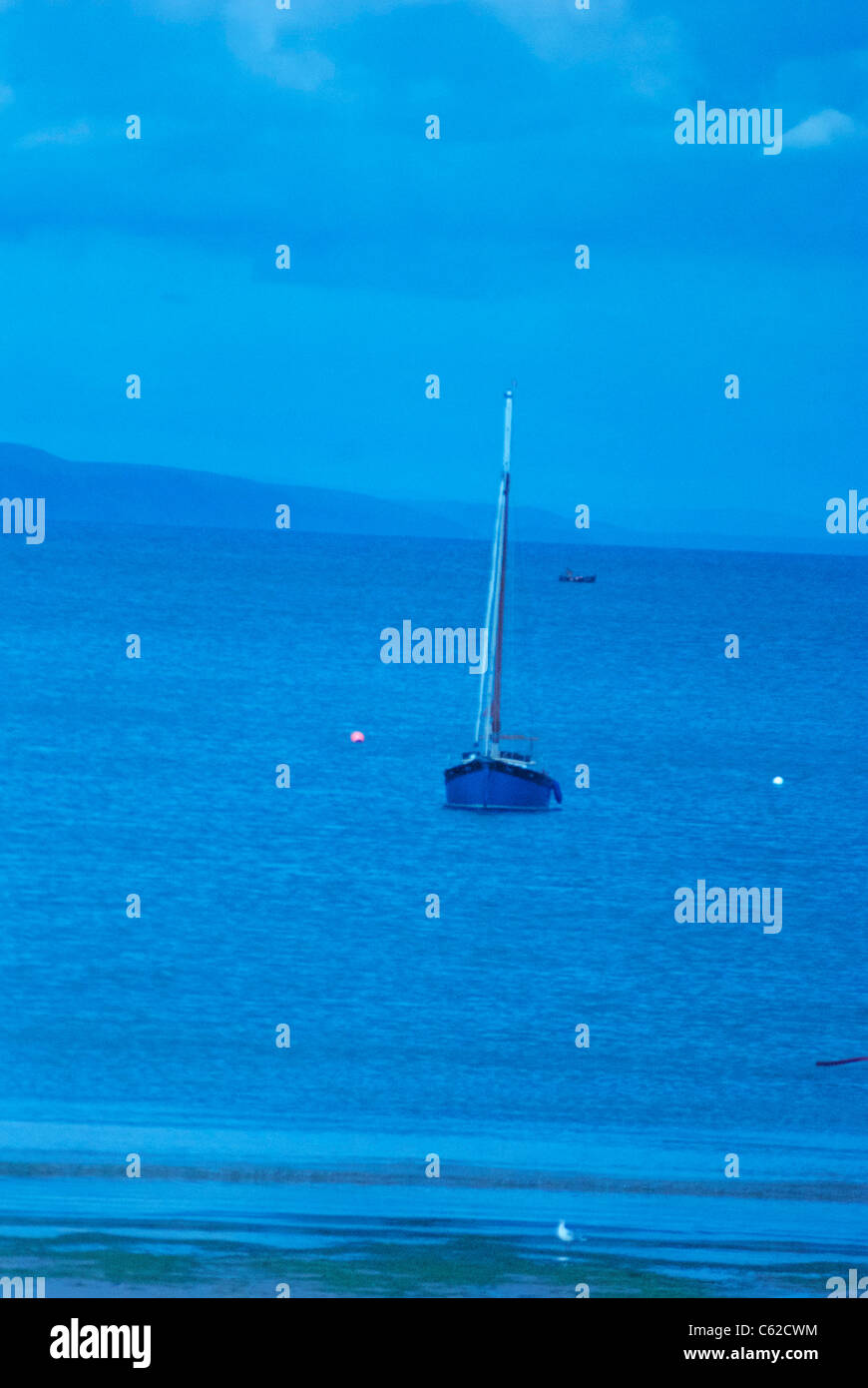Sailing boat in calm blue waters taken with tungsten light setting ...