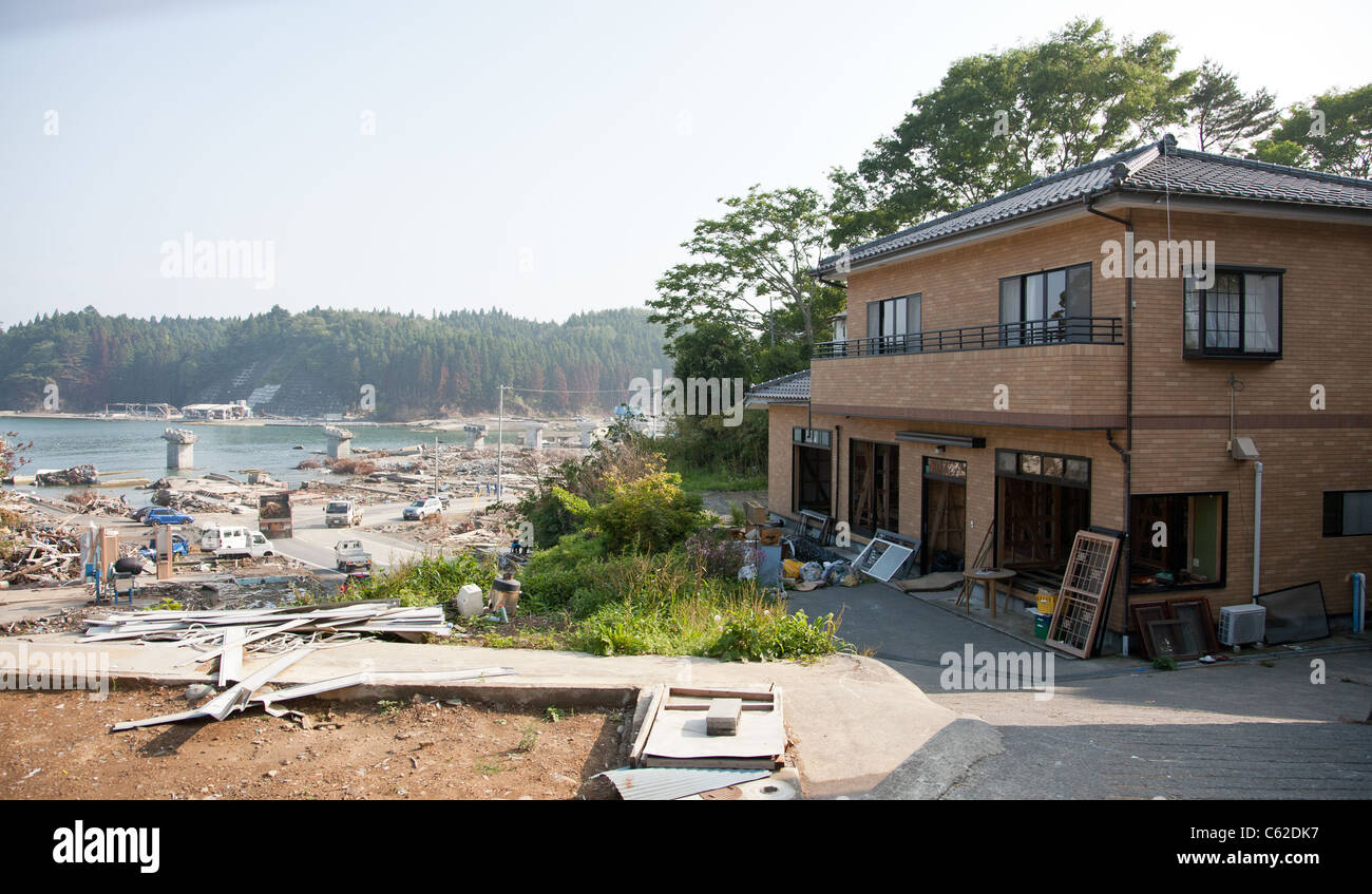 A house that has been damaged by the tsunami overlooks the bay in an ...