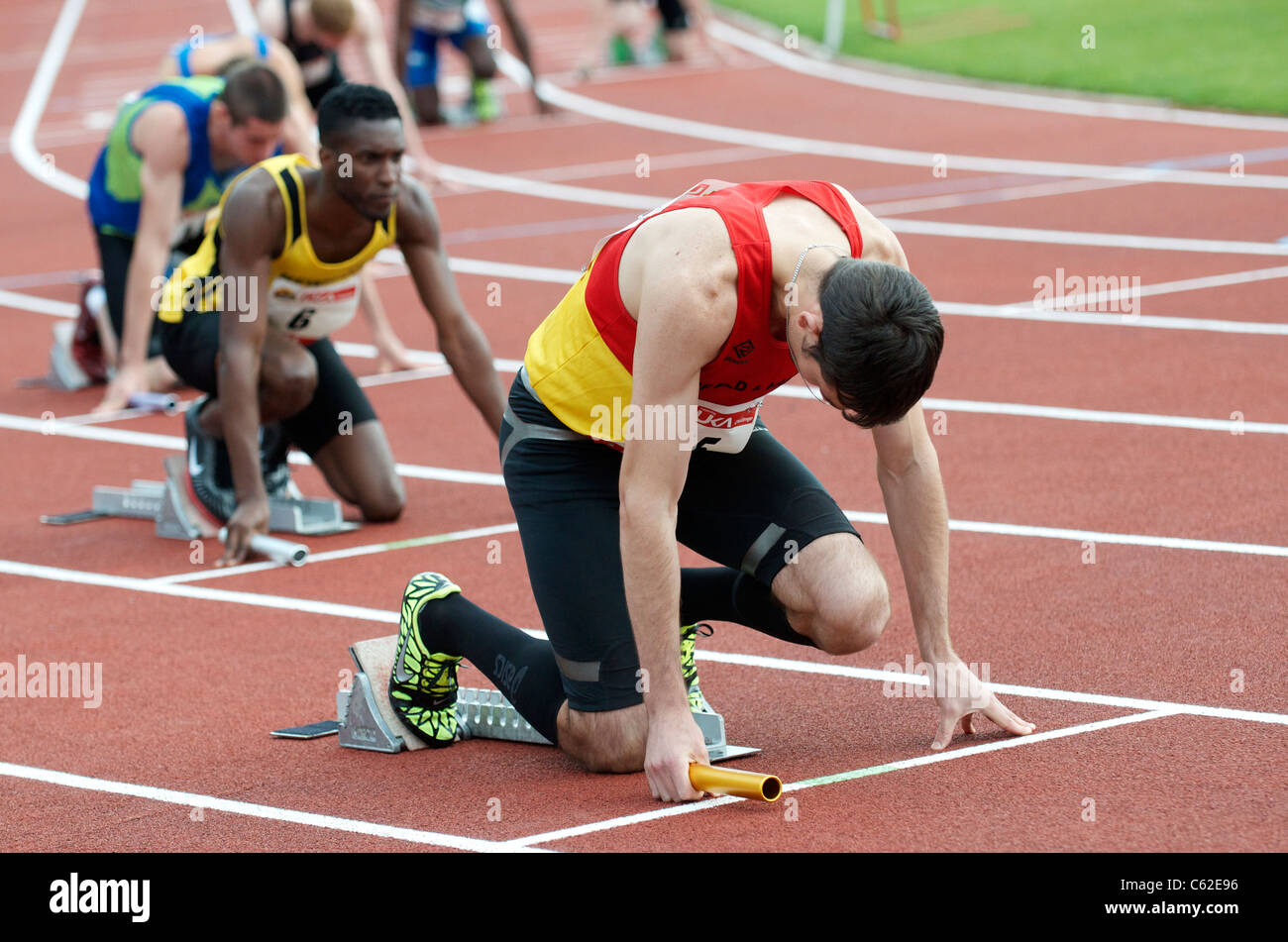 athletes at start of relay race Stock Photo - Alamy