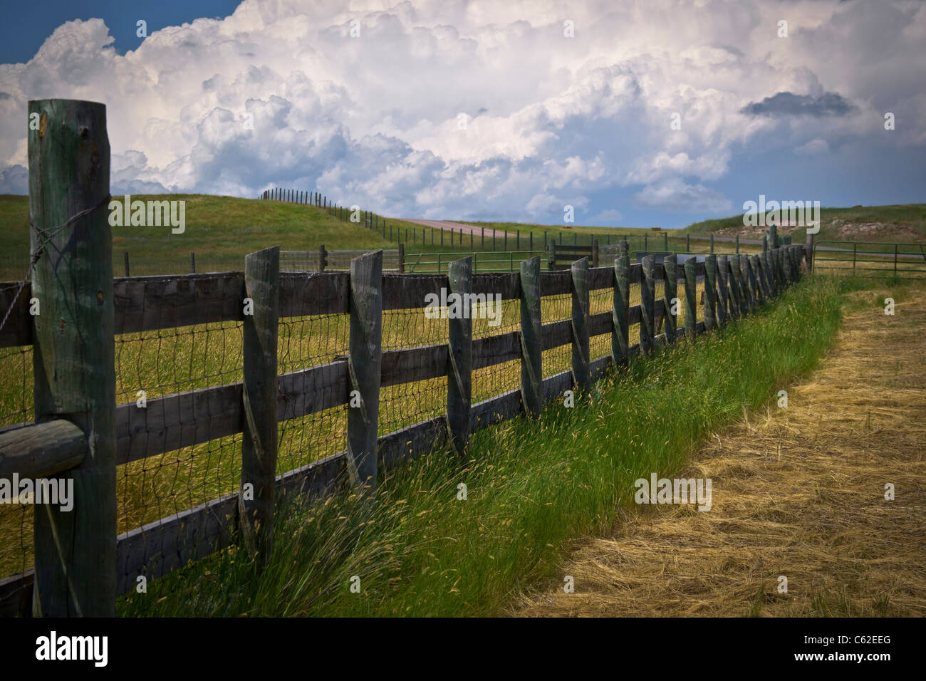 Dramatic sky with puffy sky over grasslands with wooden fence Custer ...