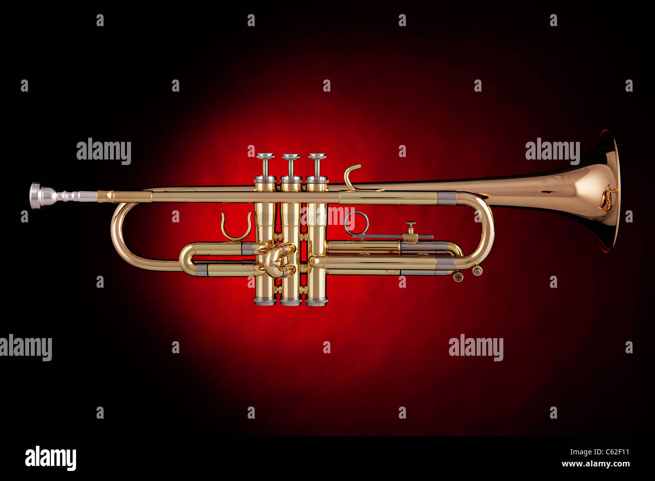 A professional gold trumpet isolated against a spotlight red background ...