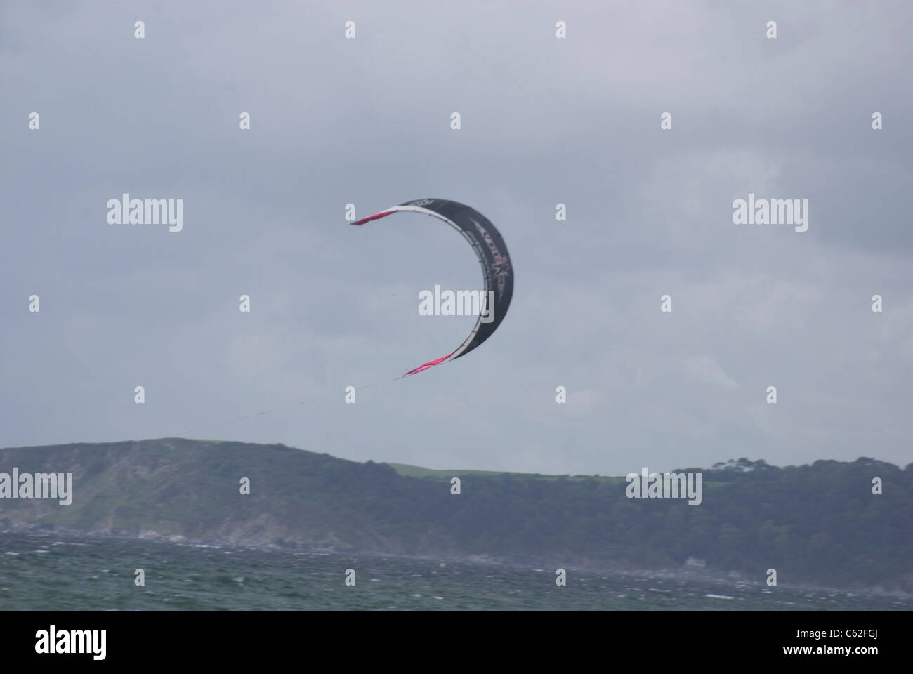 Large kite flying above sea in front of coastal land Stock Photo - Alamy
