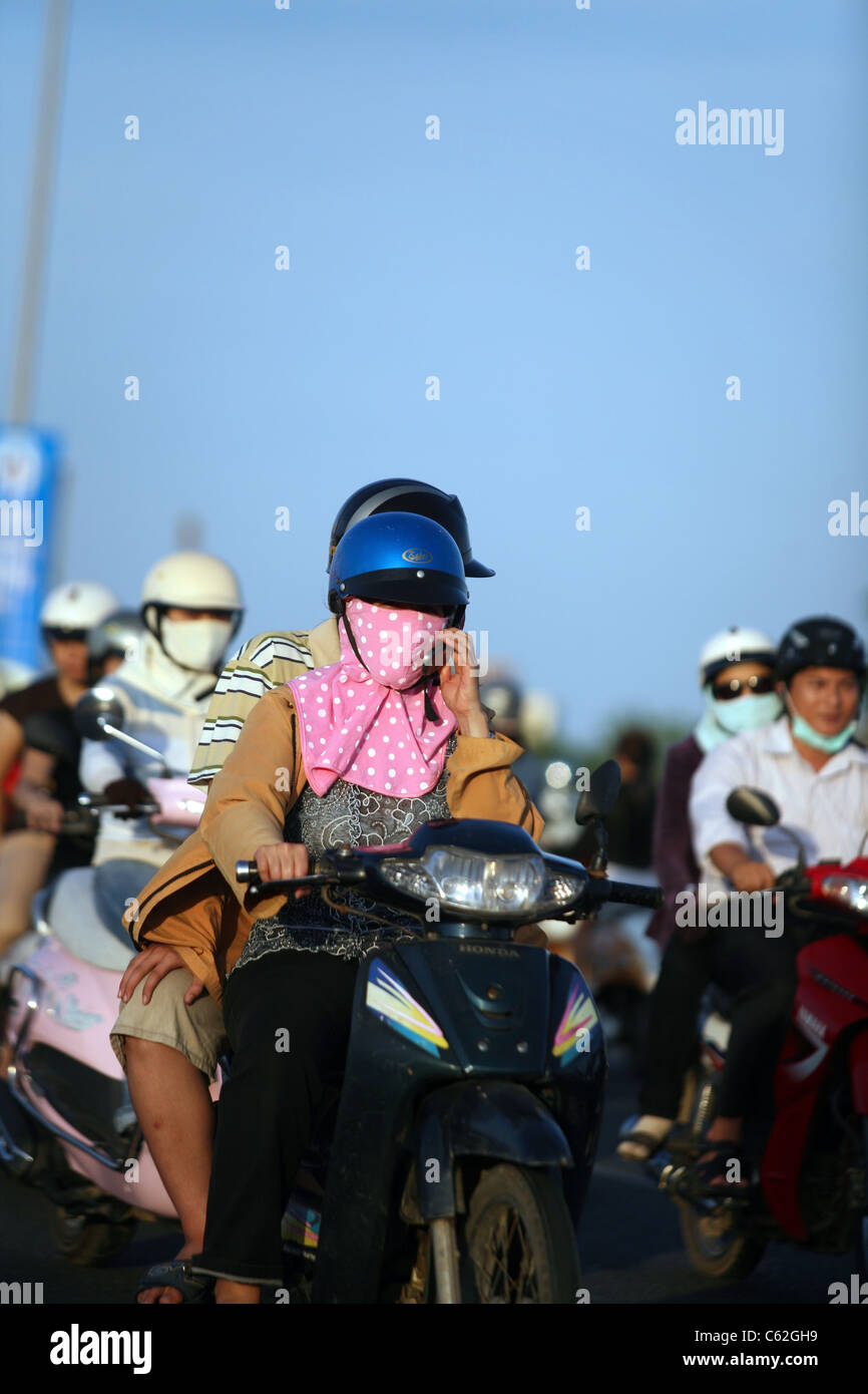 Woman with face mask riding motorbike while talking on cellphone Stock ...