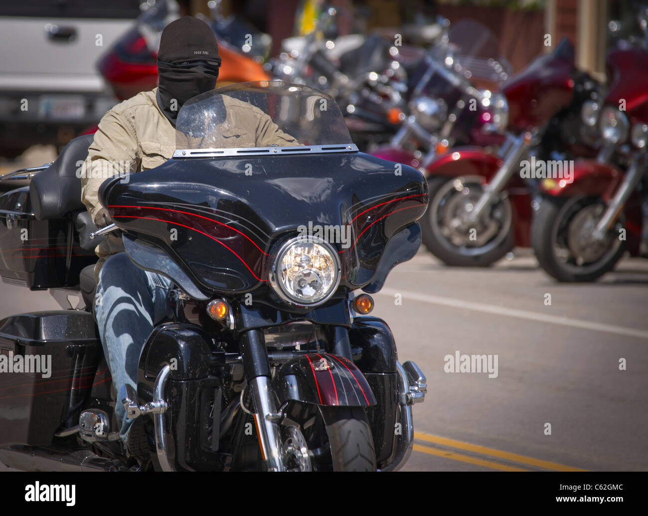 Biker wearing face mask riding motorcycle on street in Hill City South ...
