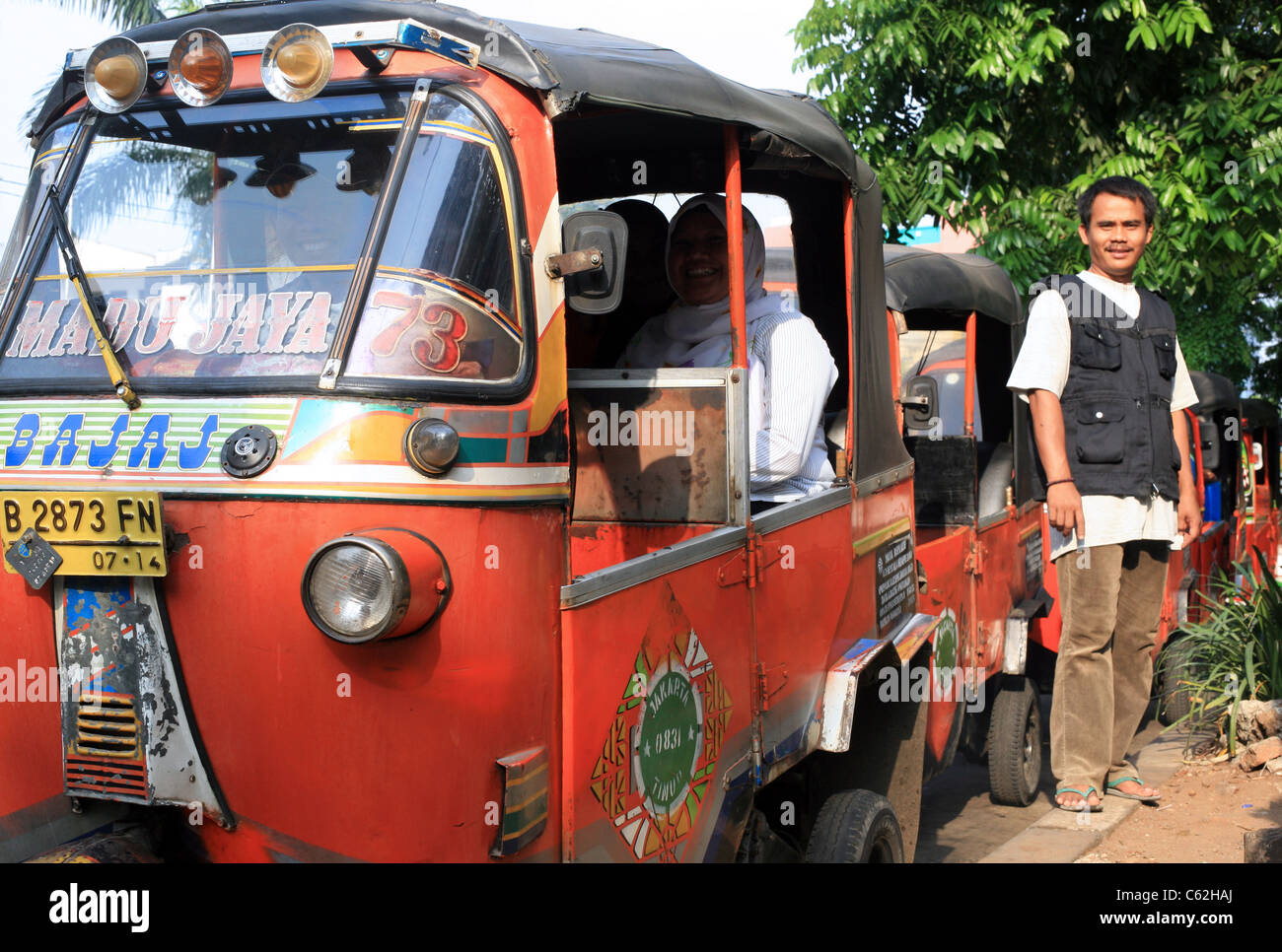 Bajaj tuk tuk passengers and driver on Jalan Wahid Hasim in Jakarta ...