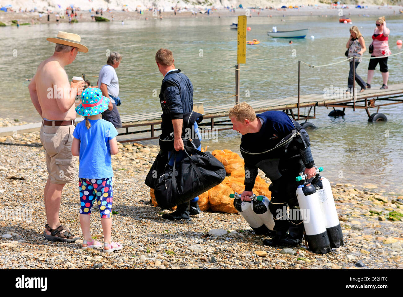 Divers bringing ashore their harvest of scallops along with their scuba gear Stock Photo - Alamy