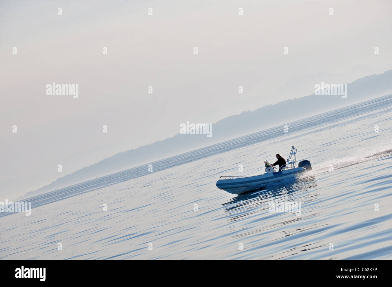 Boat cruising along horizon Stock Photo - Alamy