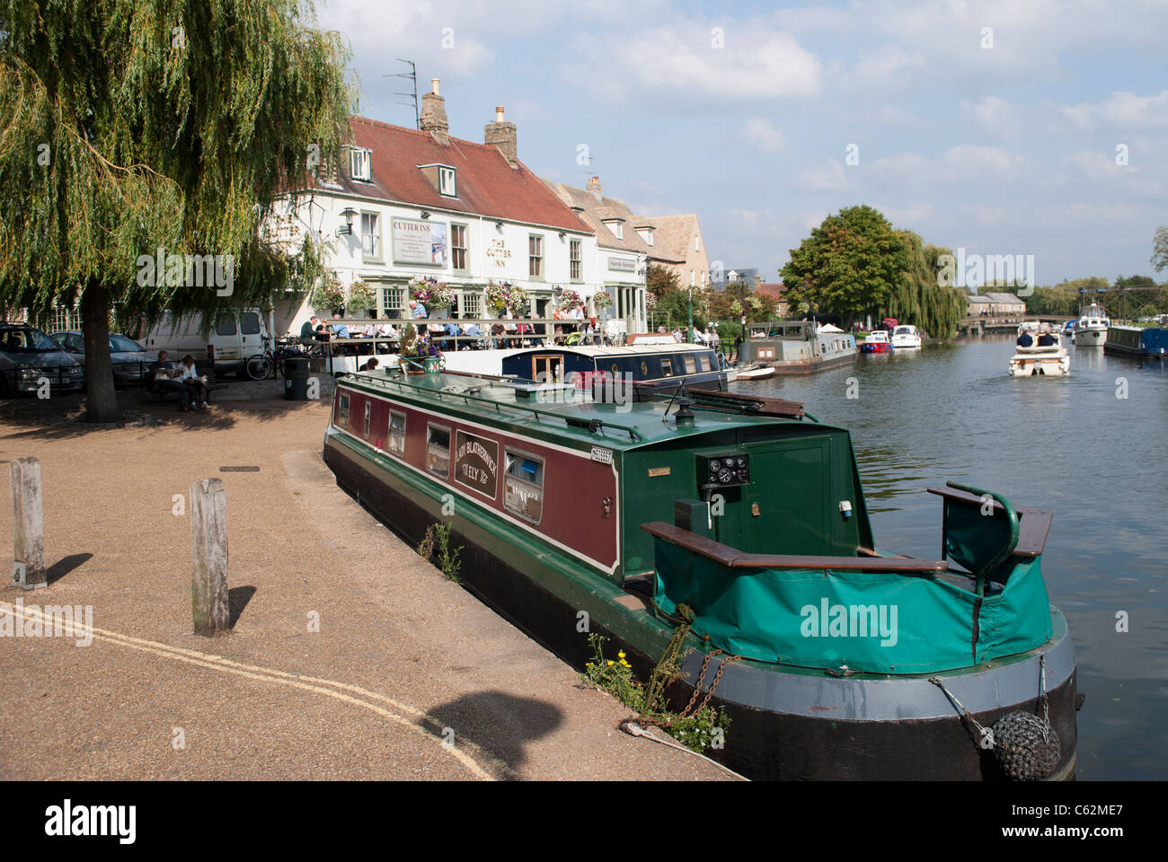 Narrowboat Lady Blatherwick mored against side of river in Ely in front ...