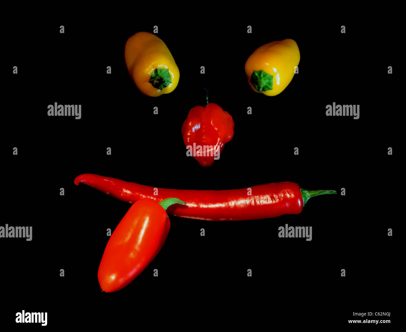 Funny face made from peppers and chillies on black background Stock ...
