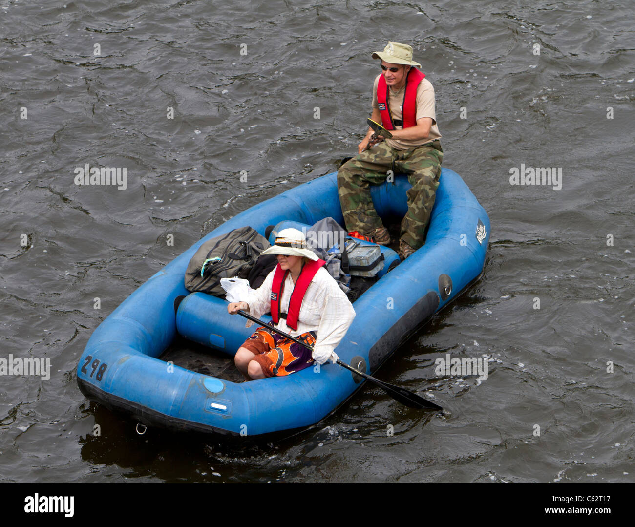 Couple man and woman in a rubber raft wearing floppy hats Stock Photo ...