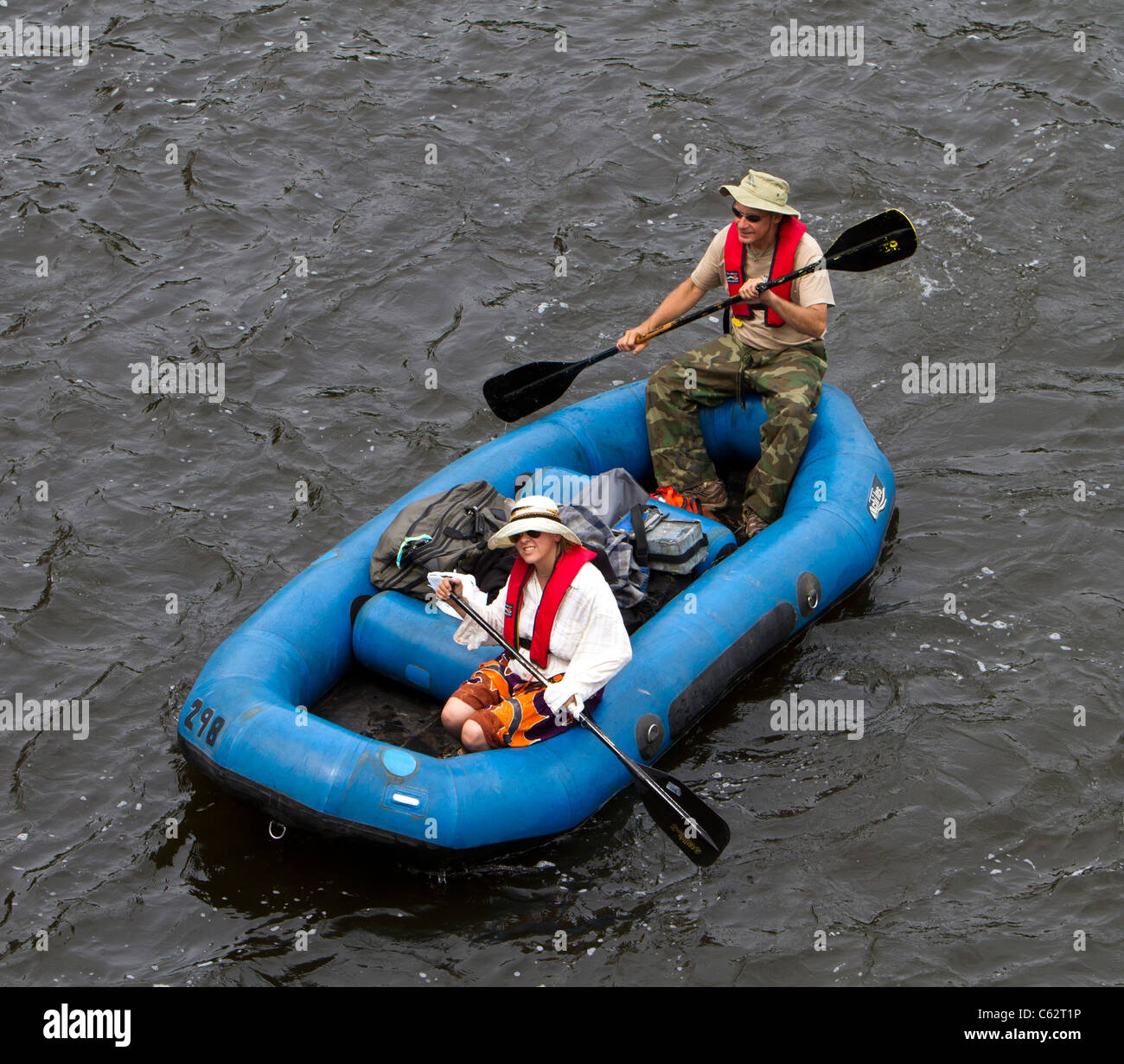 Couple man and woman in a rubber raft wearing floppy hats Stock Photo ...