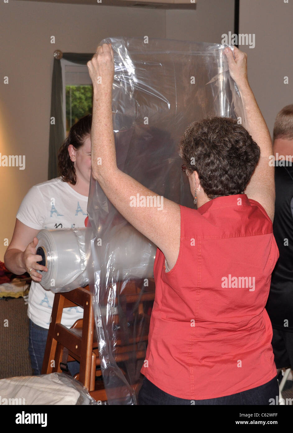 Woman prepares to wrap clothes in plastic Stock Photo - Alamy