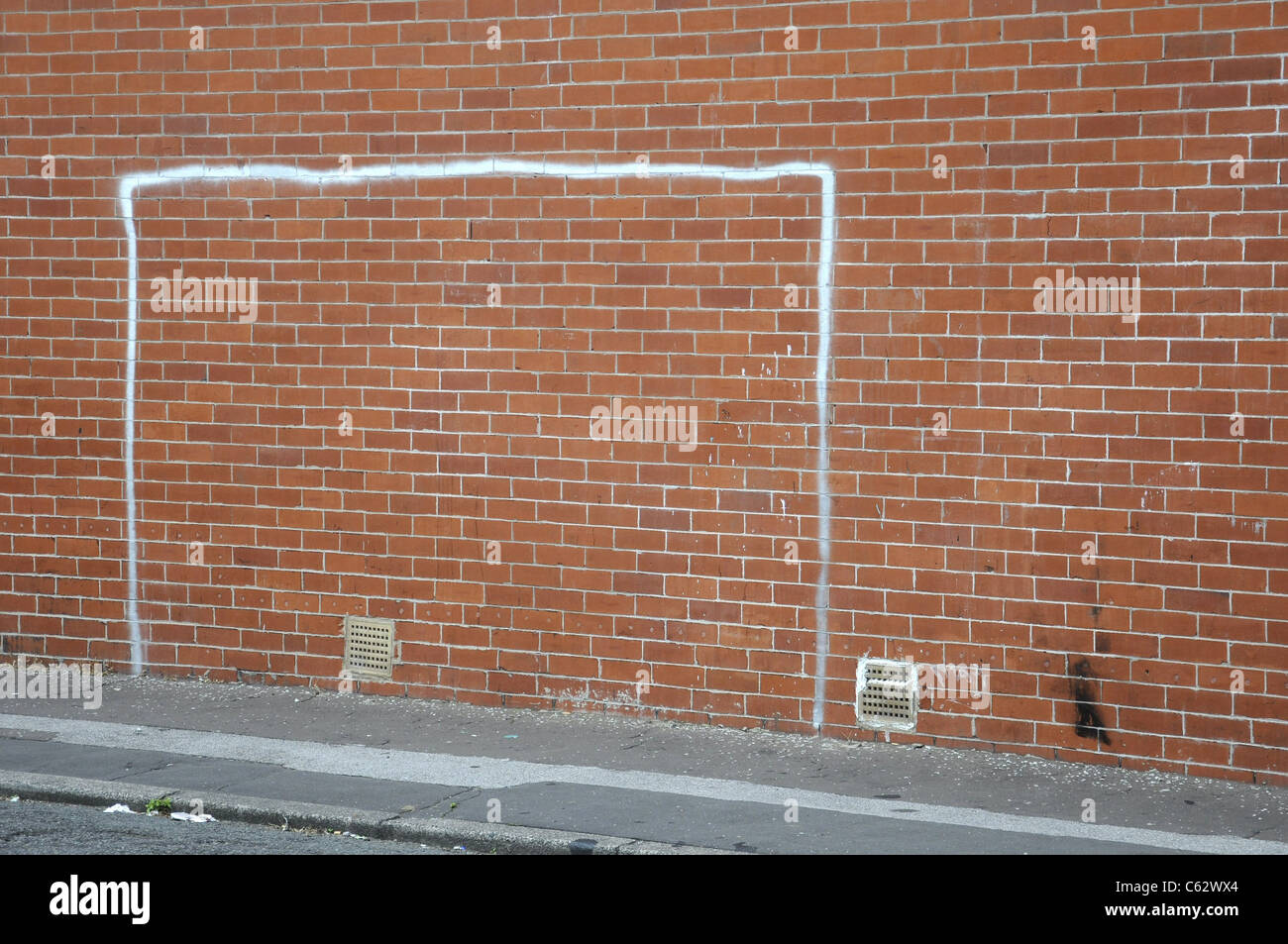 Painted goal posts and crossbar on red brick wall of house Stock Photo ...