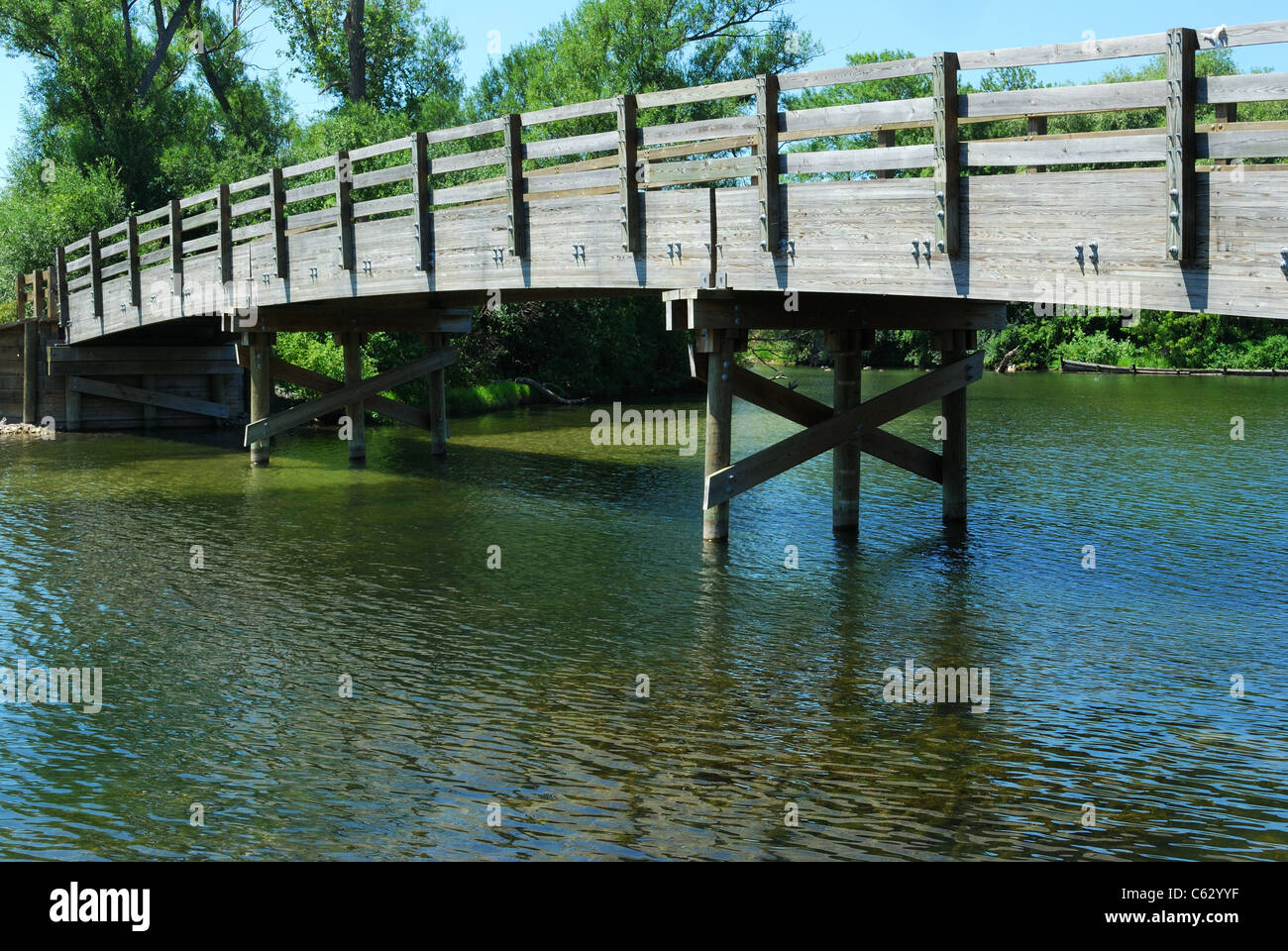 Curved wooden bridge over lagoon Stock Photo - Alamy