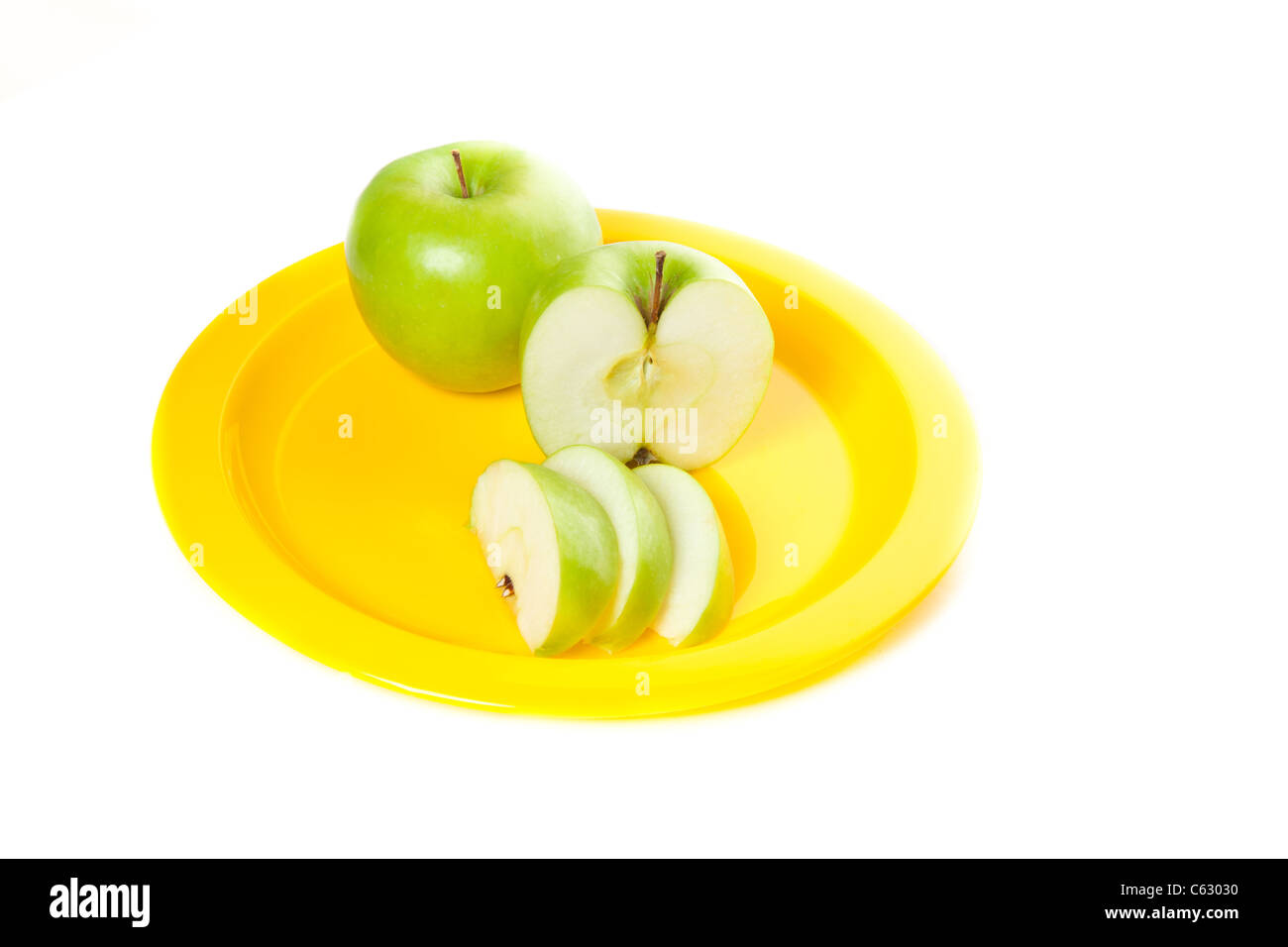 A yellow plate with green apples isolated on white Stock Photo - Alamy