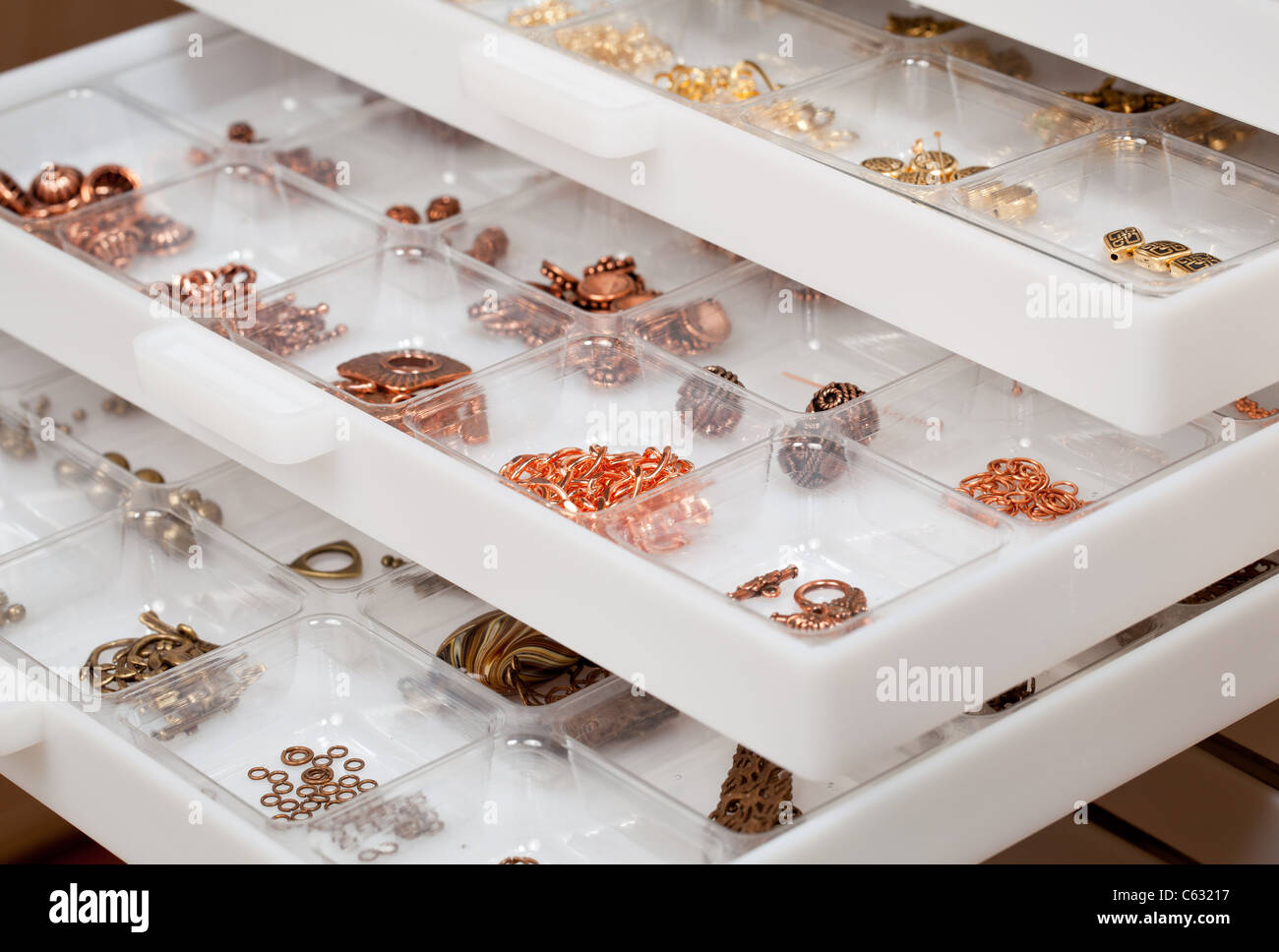 Small metal parts used to create home made jewelry and stored in white ...