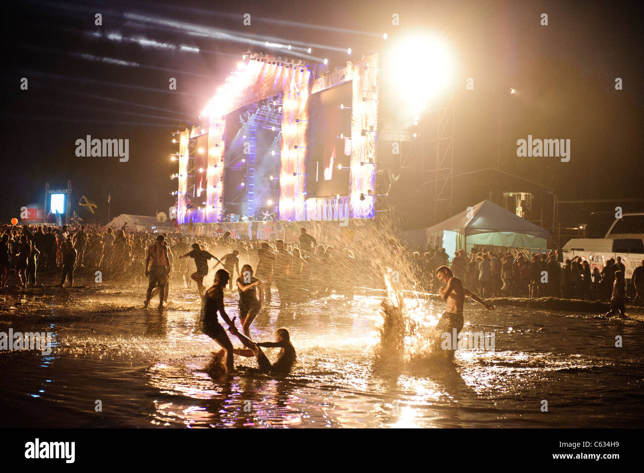Young people having fun in the mud at the Przystanek Woodstock - Europe ...