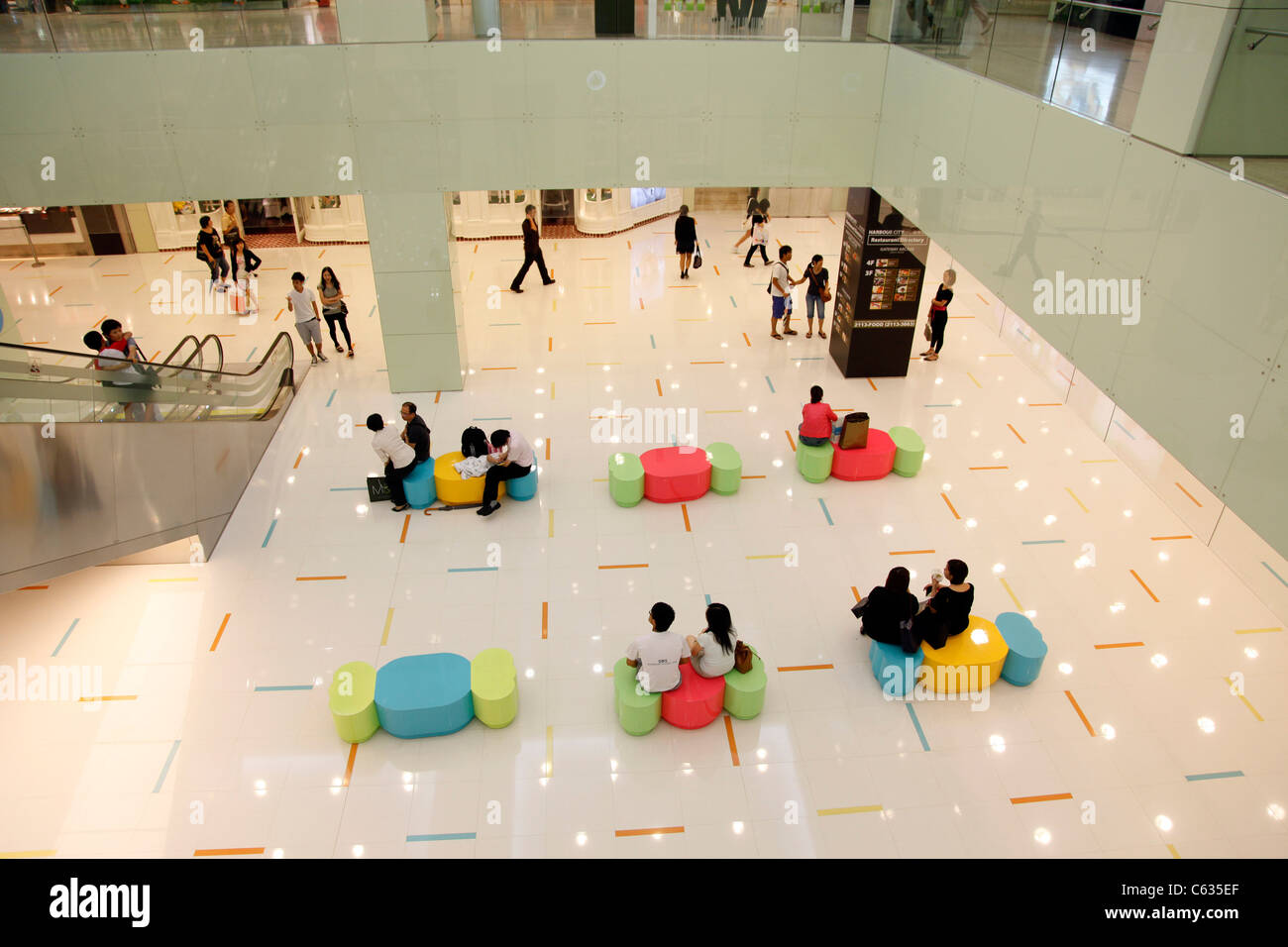 People sitting on seats resting in a shopping mall in Hong Kong, China ...