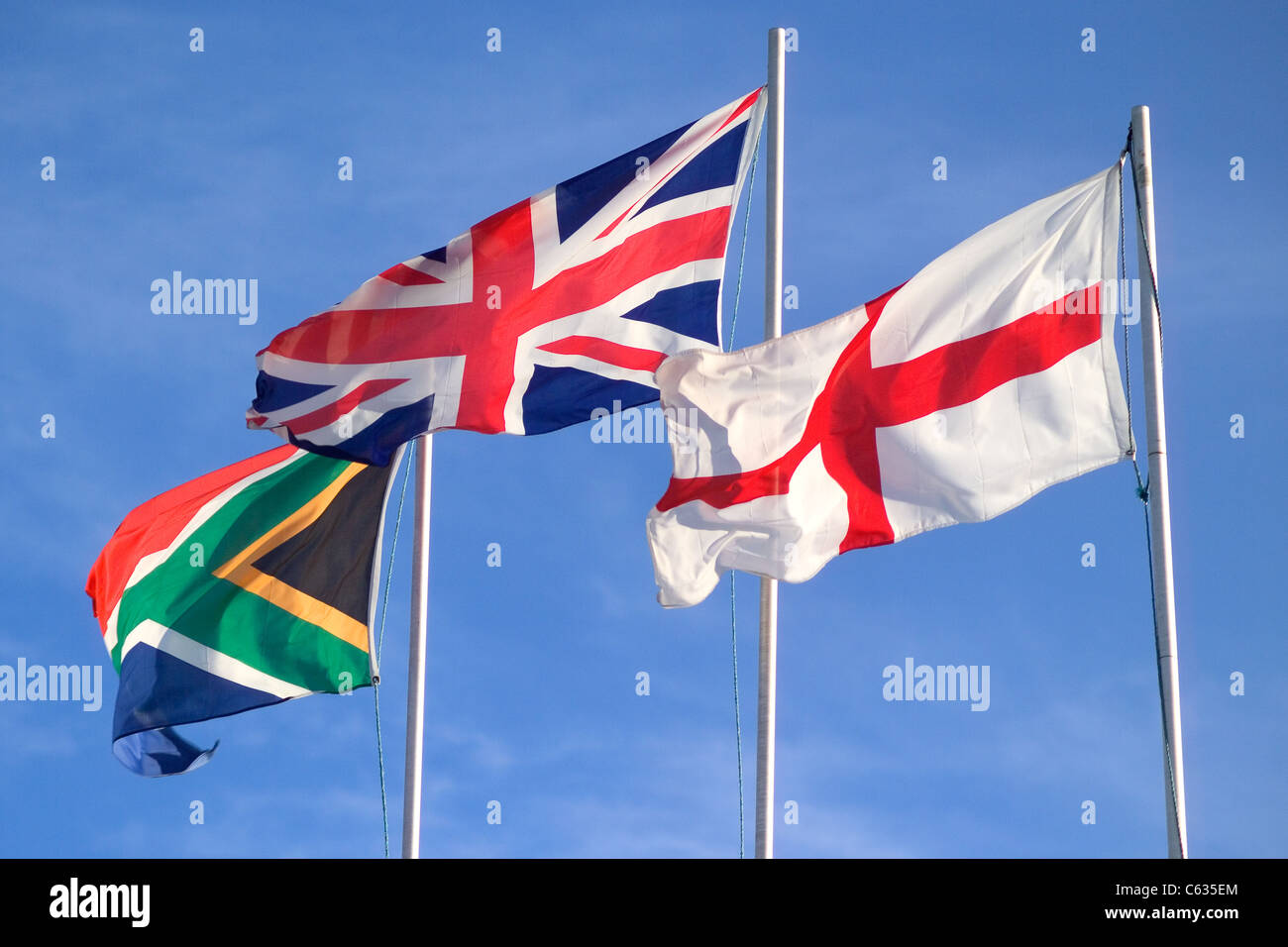 Three flags flying in a blue sky: South African flag, Union Jack and ...