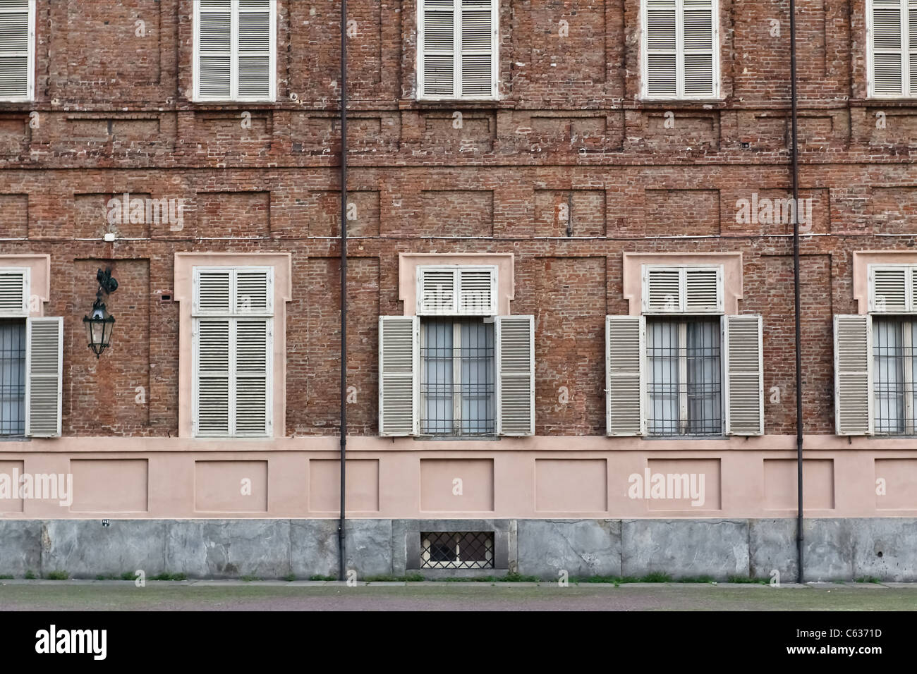 A facade of a brick building with white wooden windows on a square in ...