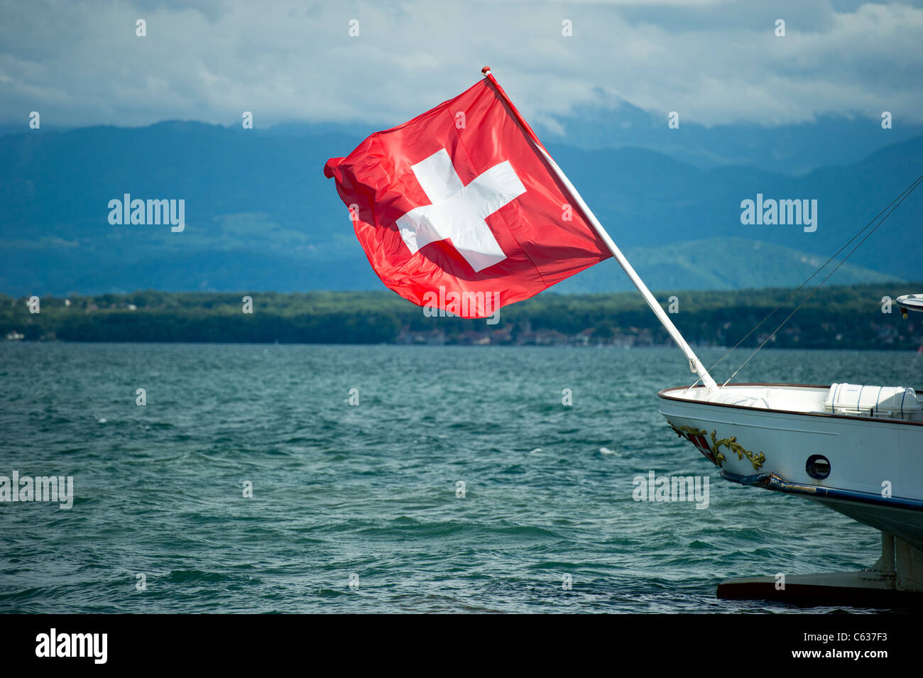 Swiss flag flying in the wind at rear of pleasure boat on Lac Leman ...