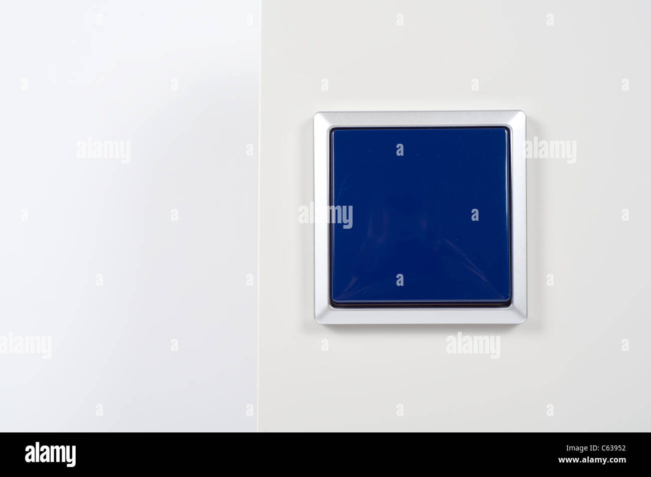 light switch on the wall with blue button on silver frame Stock Photo ...